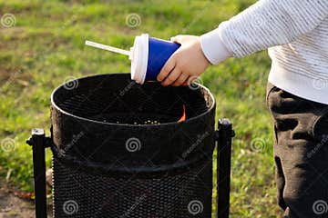A Child Throws a Plastic Cup in the Trash. Garbage Recycling and ...