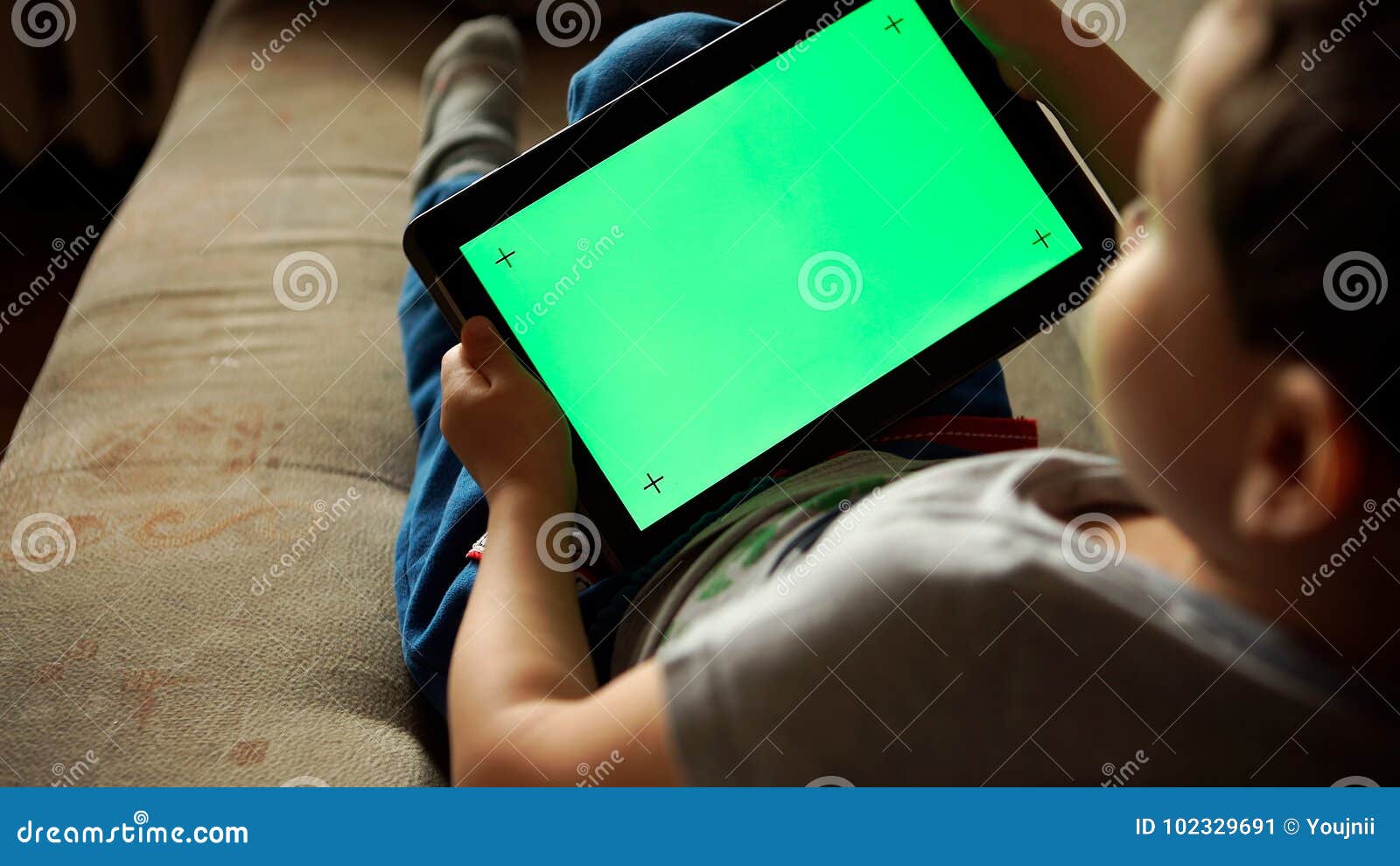Child Tilting To the Left a Tablet PC with Green Screen, Back View ... Child Tilting To the Left a Tablet PC with Green Screen, Back View ...