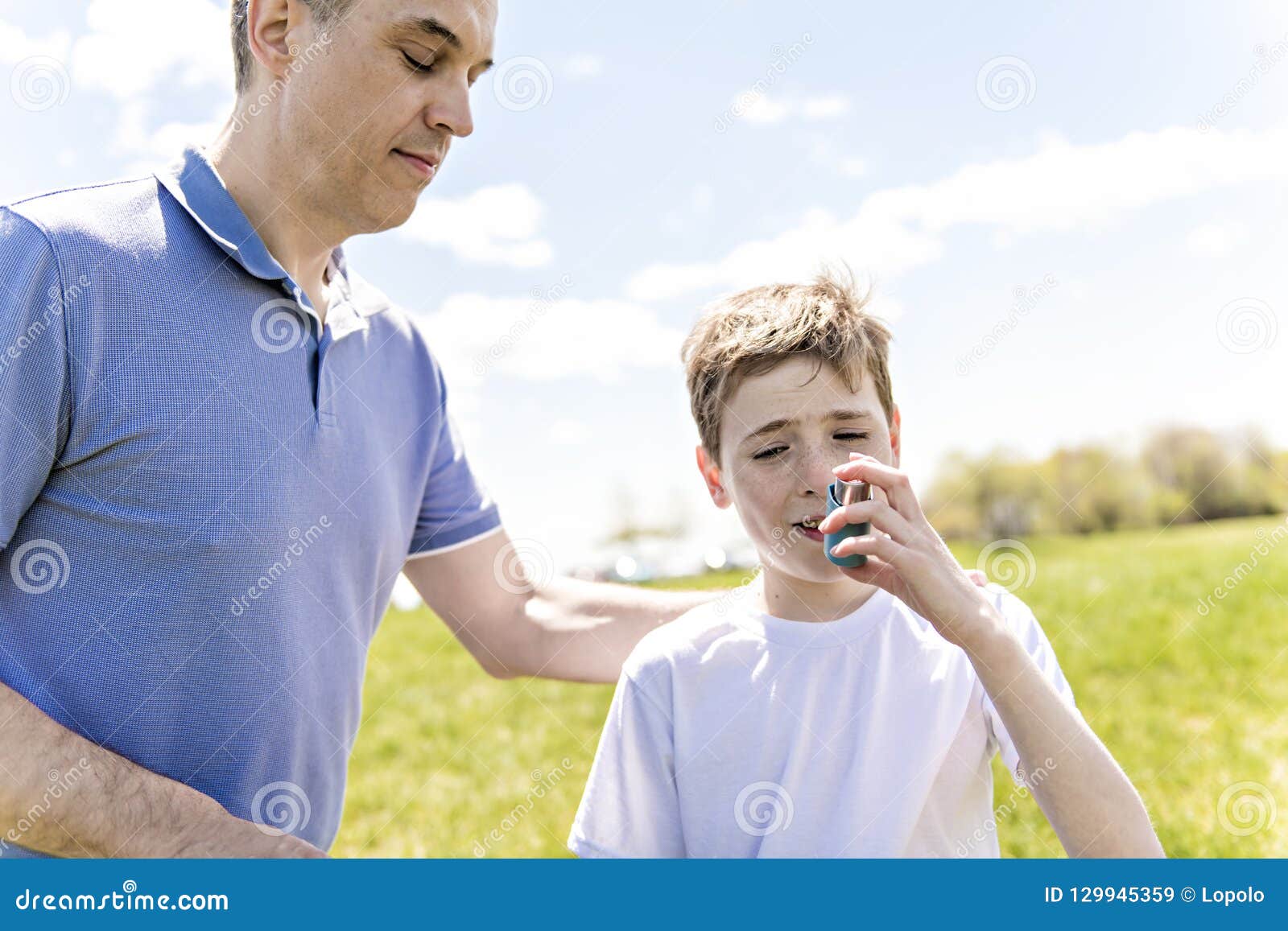 Child Using Inhaler for Asthma Outside in a Park with His Father Stock ...