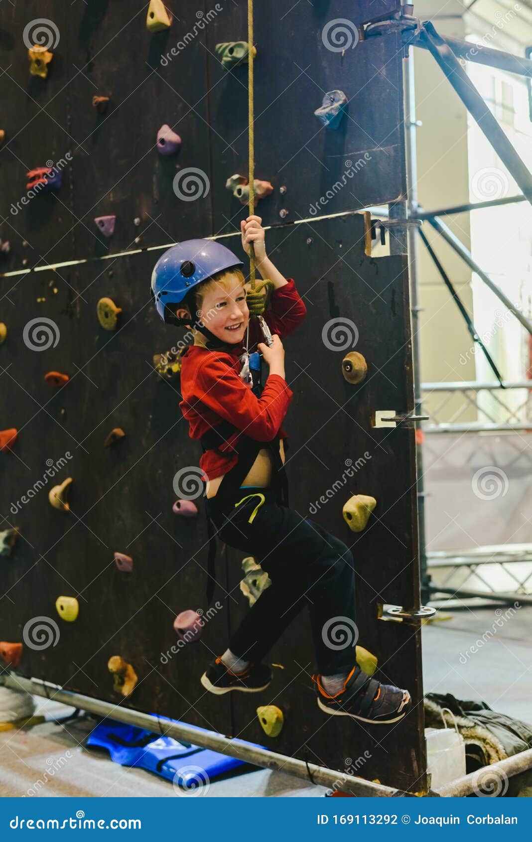 Child on the Walls of a Climbing Wall with the Help of a Safety Rope ...
