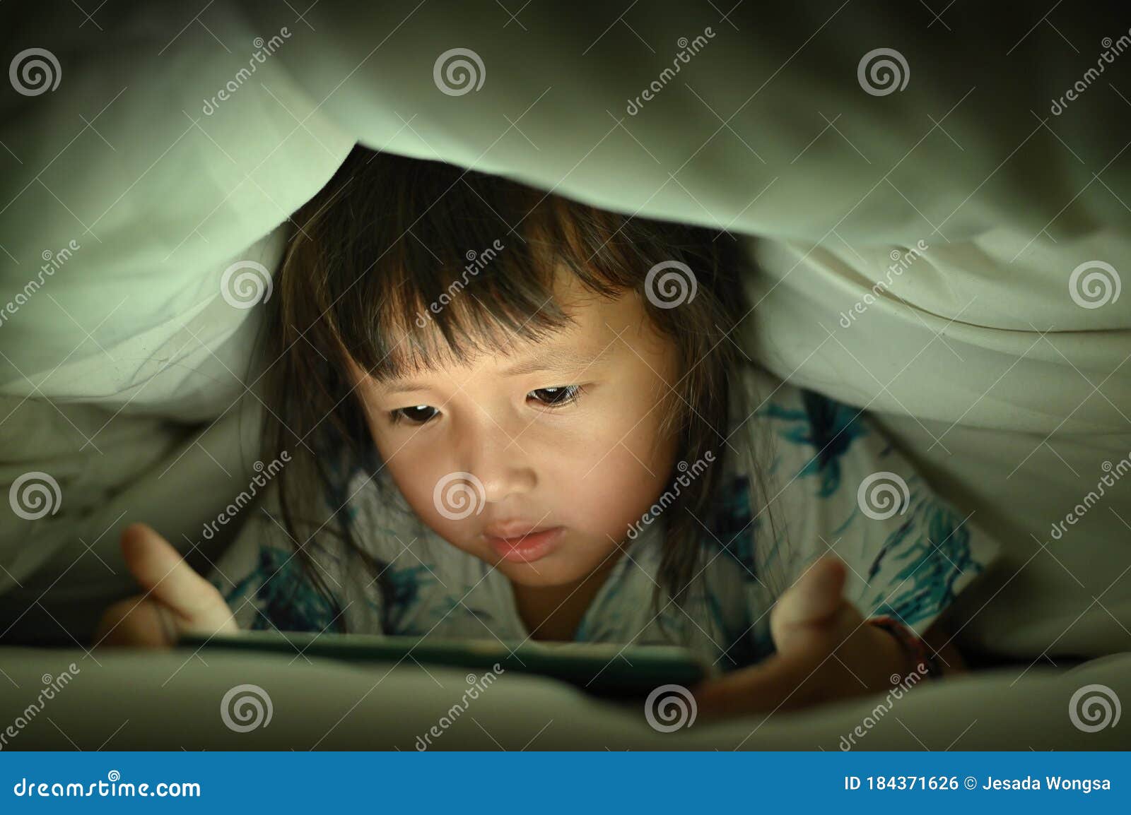 Child are Watching Video Smart Phone Under the Blanket on Bed at Night ...