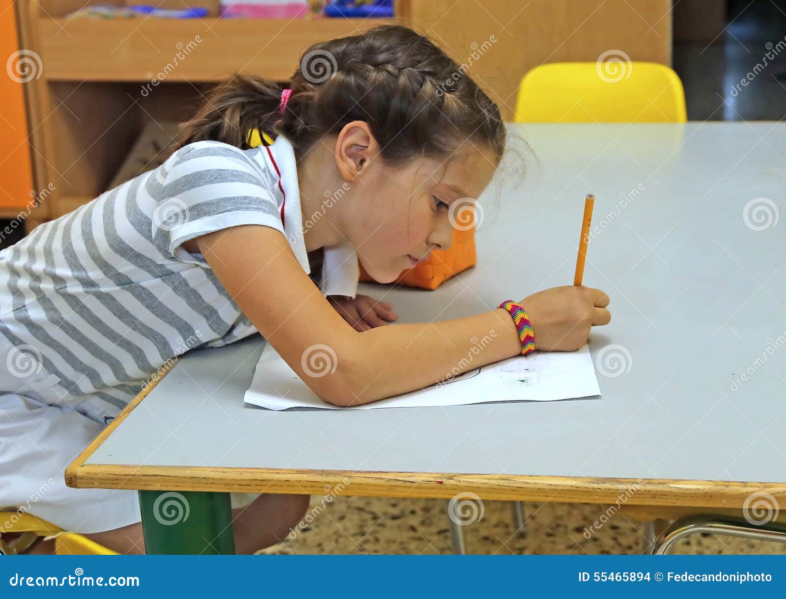 Child Writes on Paper with Pencil in Classroom Stock Photo - Image of ...