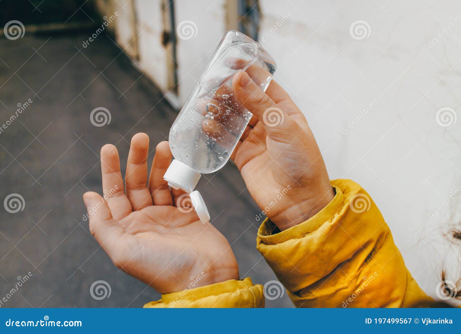 A Child in a Yellow Jacket. in Hands a Bottle with Gel for Processing ...