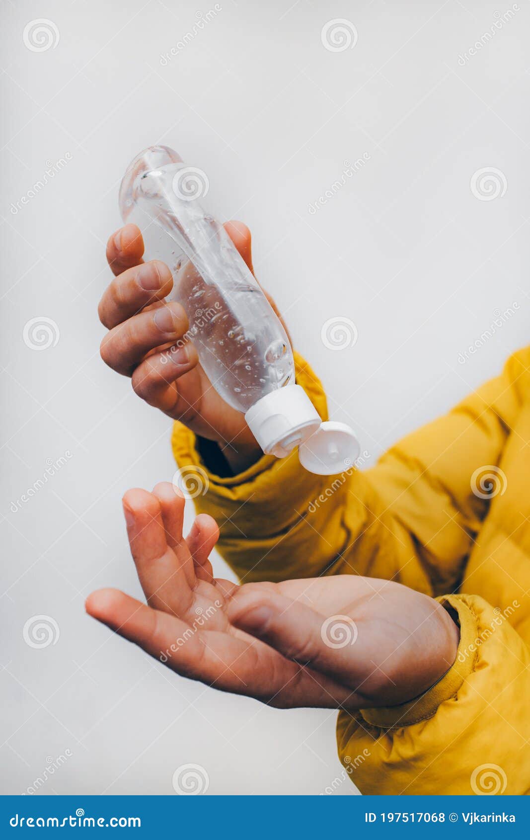A Child in a Yellow Jacket. in Hands a Bottle with Gel for Processing ...