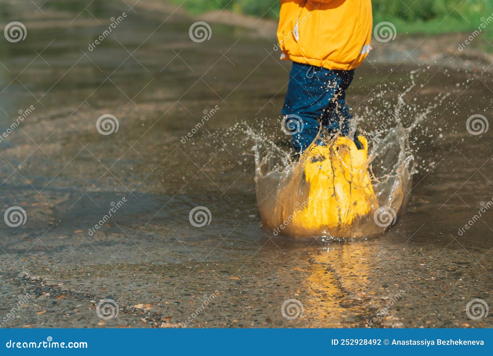 Child in Yellow Rubber Boots Jumping through Puddles Stock Photo ...
