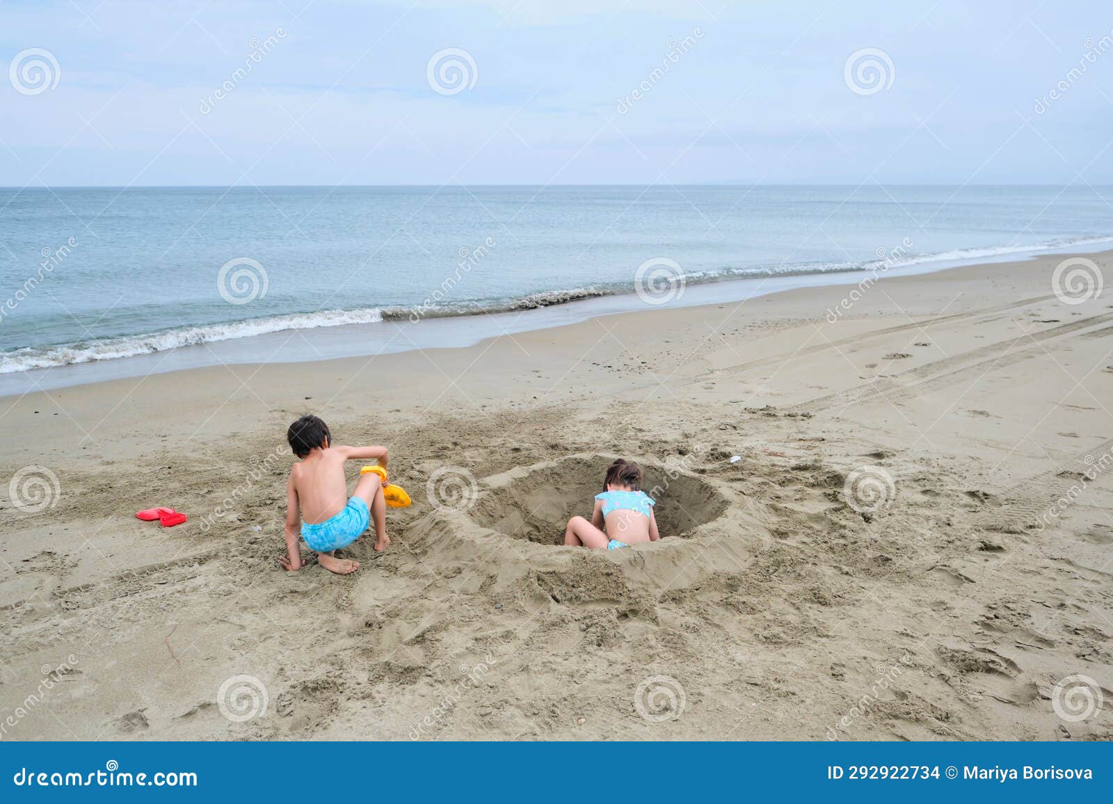 Children Dig a Hole in the Sand on the Seashore. Stock Photo - Image of ...