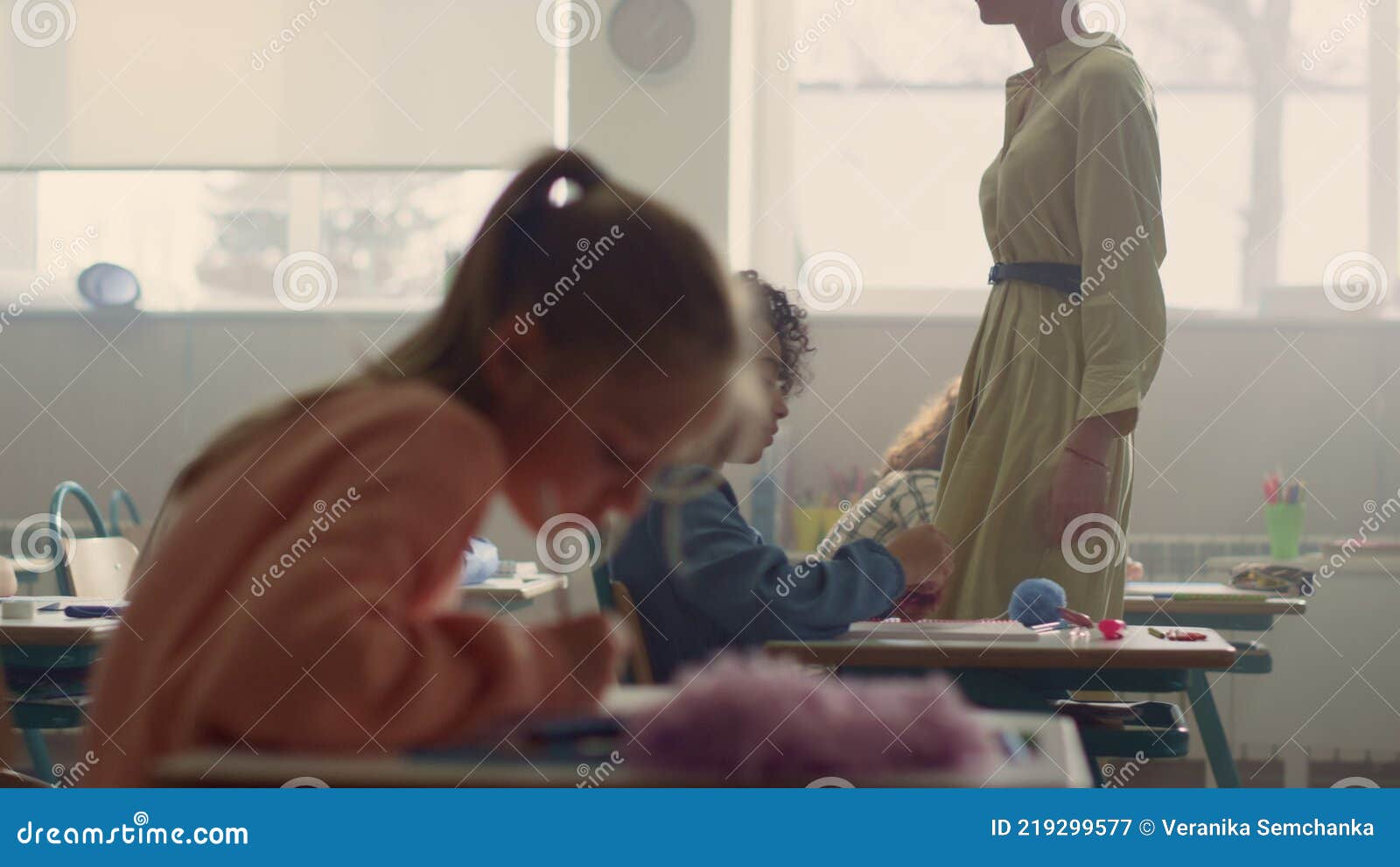 Children Doing Class Work at Desks. Teacher Explaining Lesson To Pupils ...