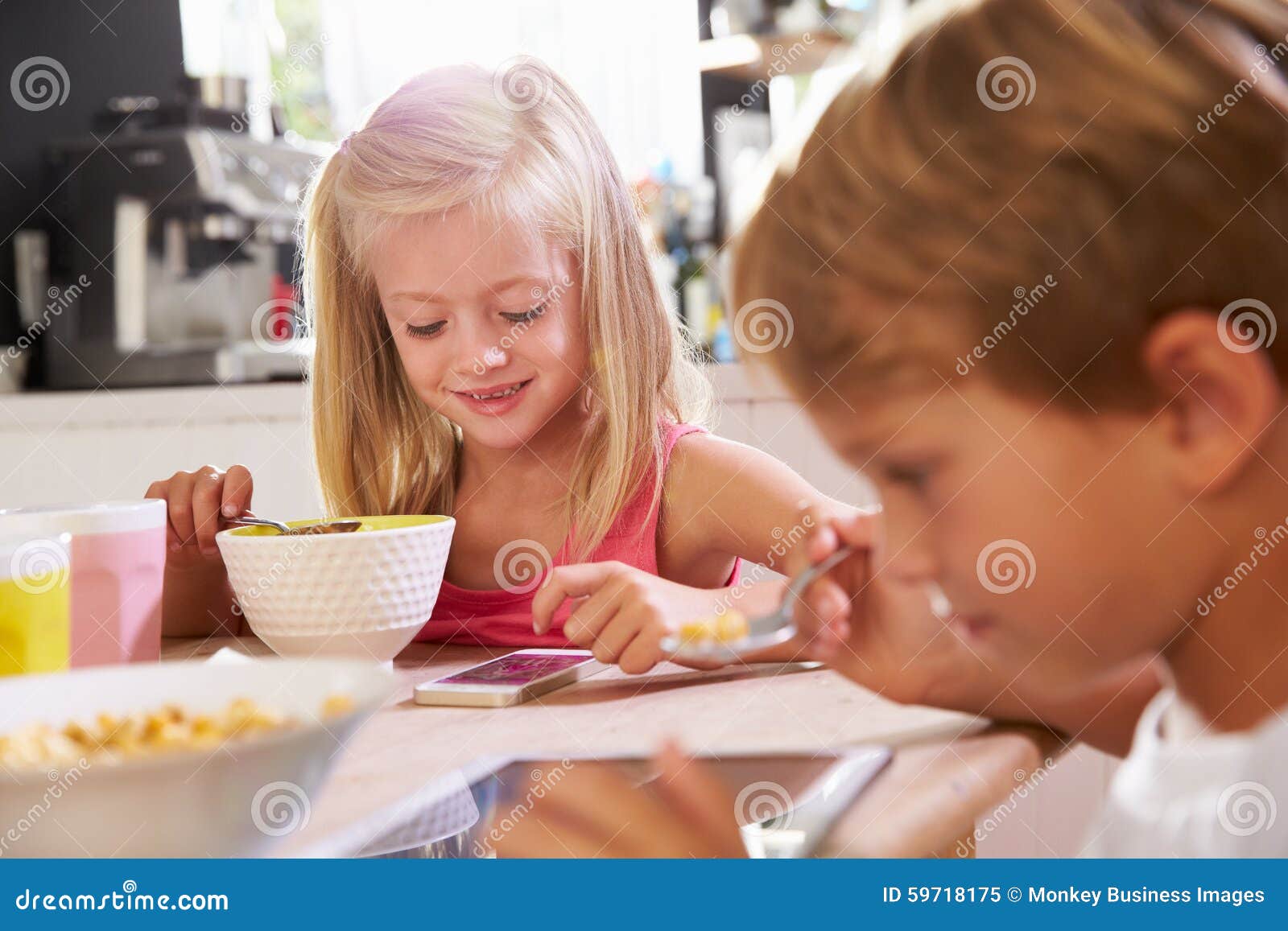Children Eating Breakfast Whilst Playing with Mobile Phone Stock Image ...