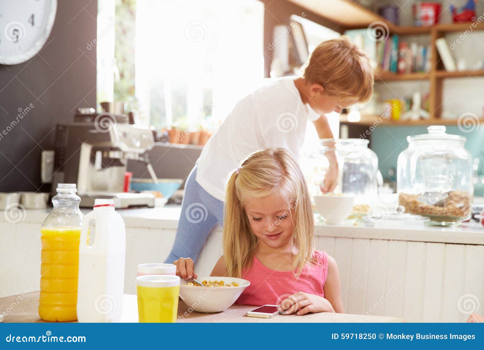 Children Eating Breakfast Whilst Playing with Mobile Phone Stock Photo ...