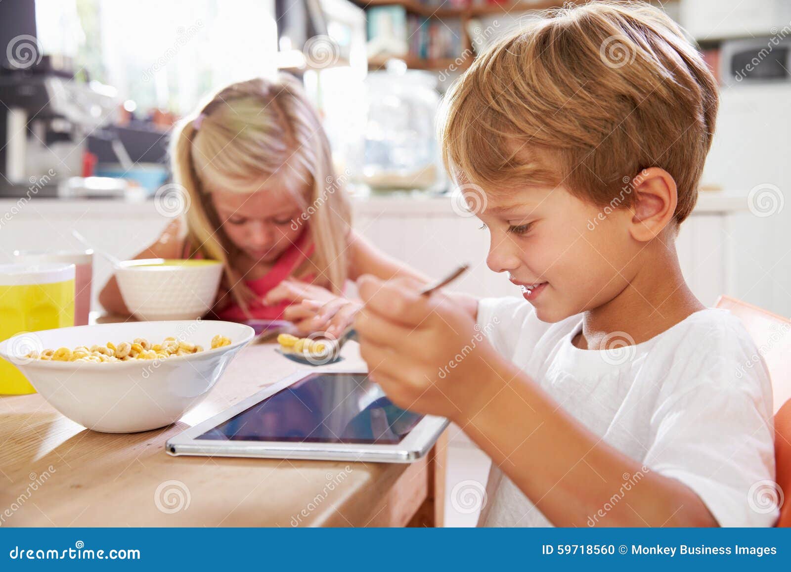 Children Eating Breakfast Whilst Using Digital Tablet Stock Photo ...