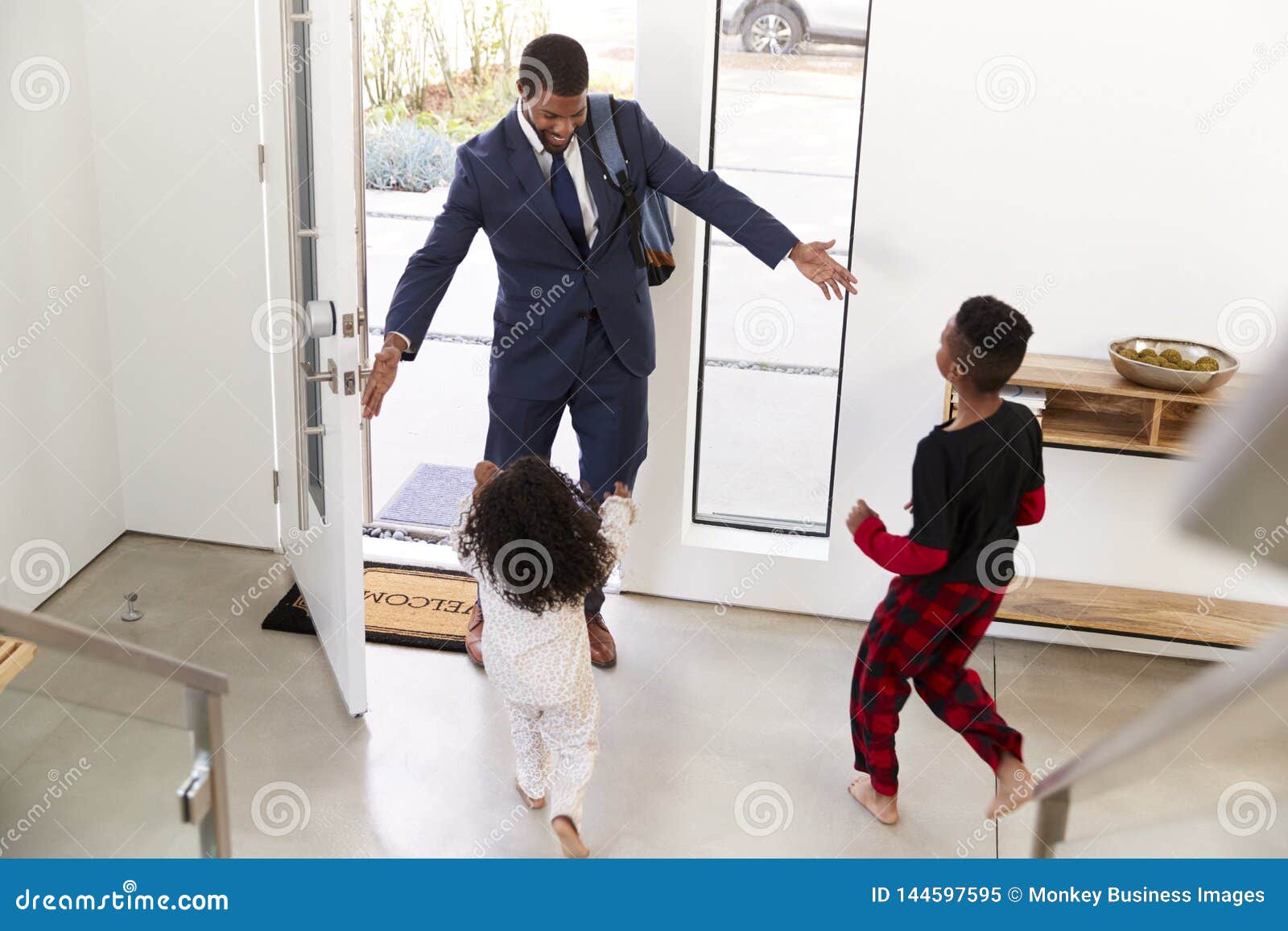 Children Greeting and Hugging Working Businessman Father As he Returns ...