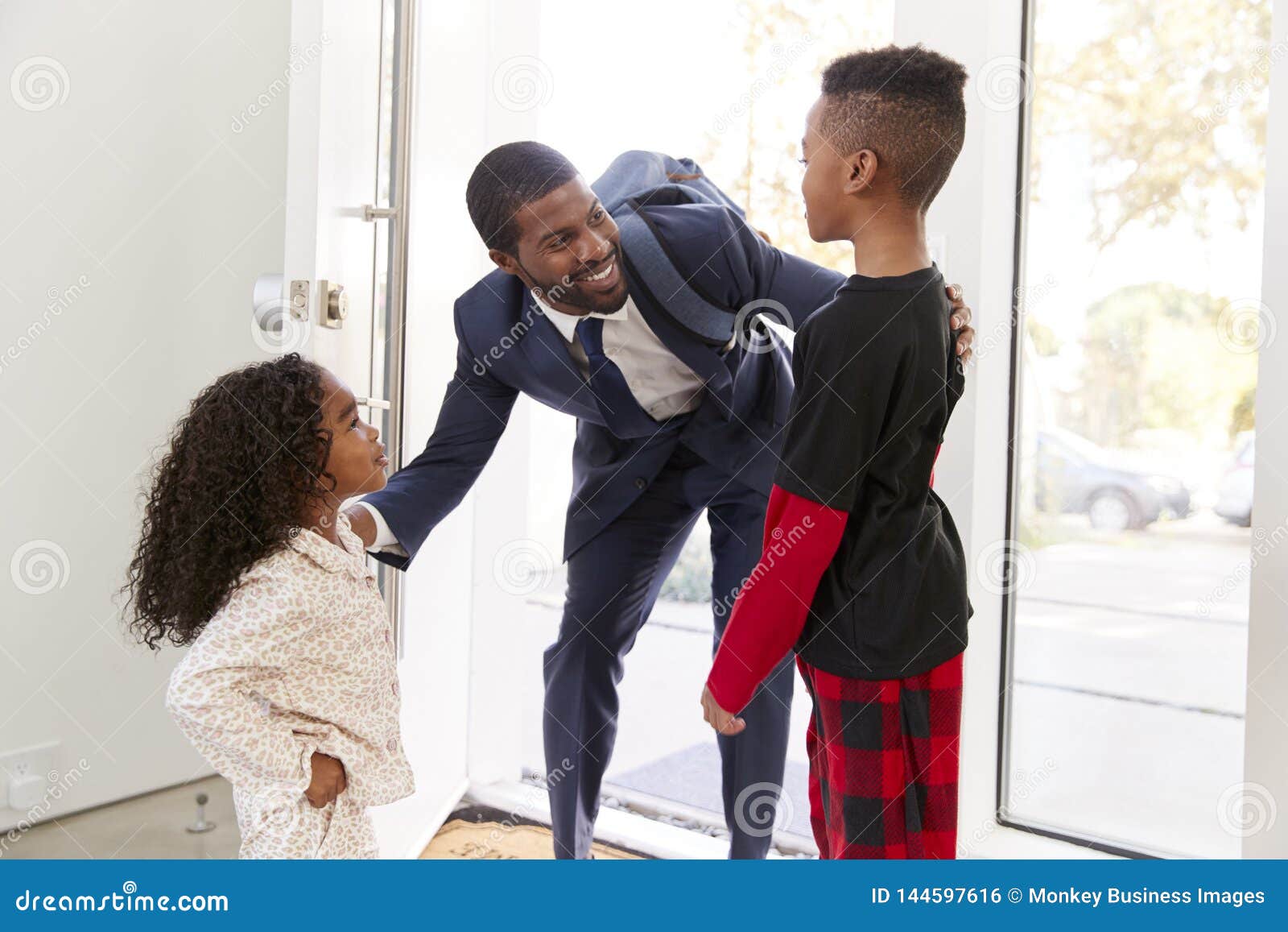 Children Greeting and Hugging Working Businessman Father As he Returns ...