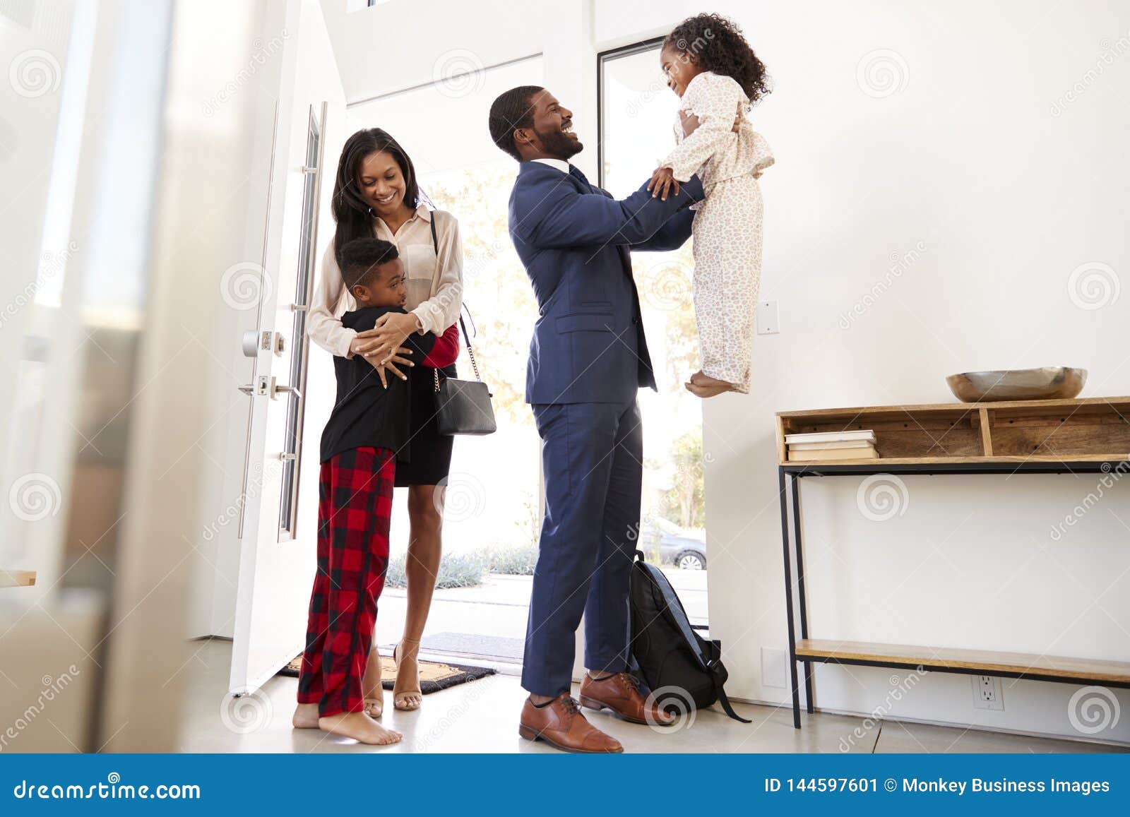 Children Greeting and Hugging Working Parents As they Return Home from ...