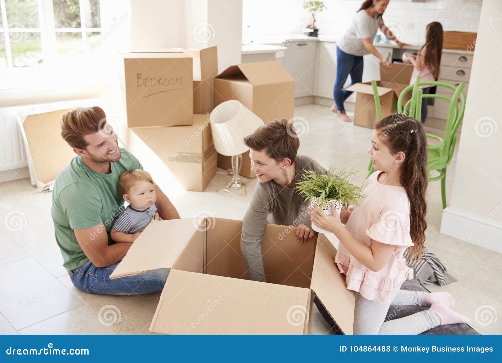 Children Helping Parents To Unpack on Moving in Day Stock Photo - Image ...