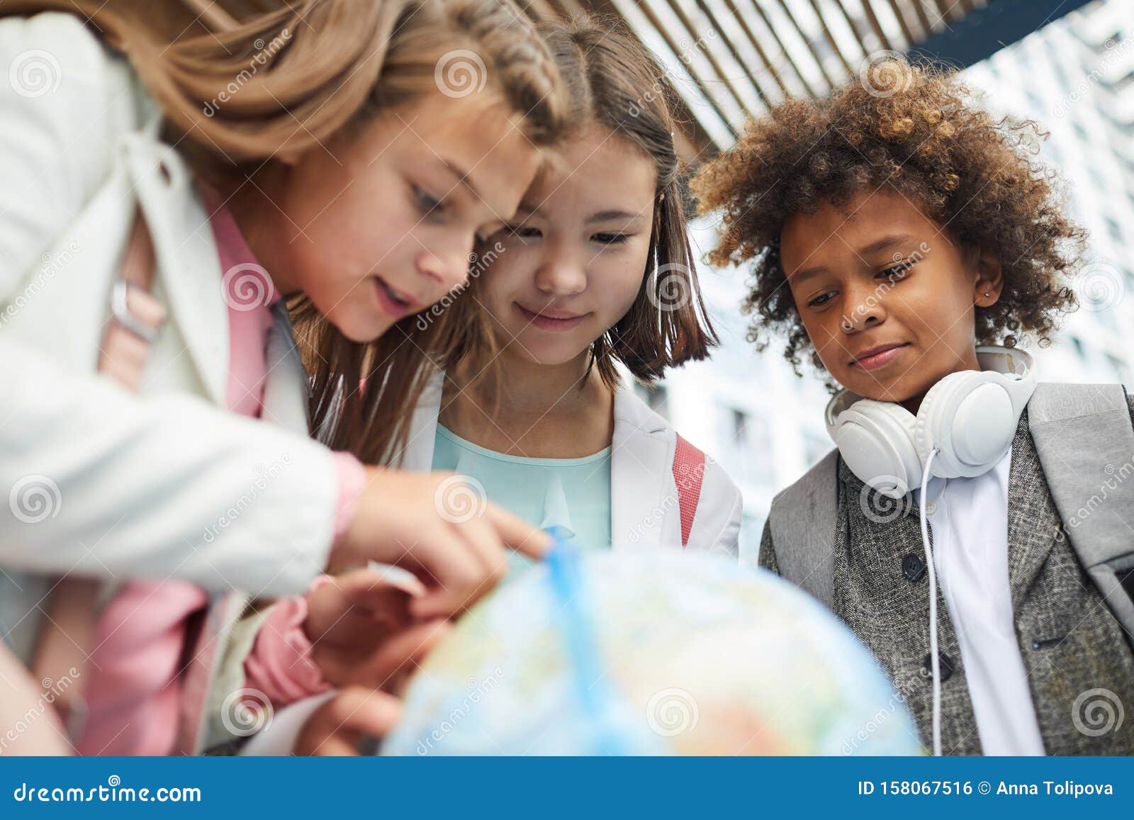 Row Of Multiethnic Elementary Students Reading Book In Classroom ...