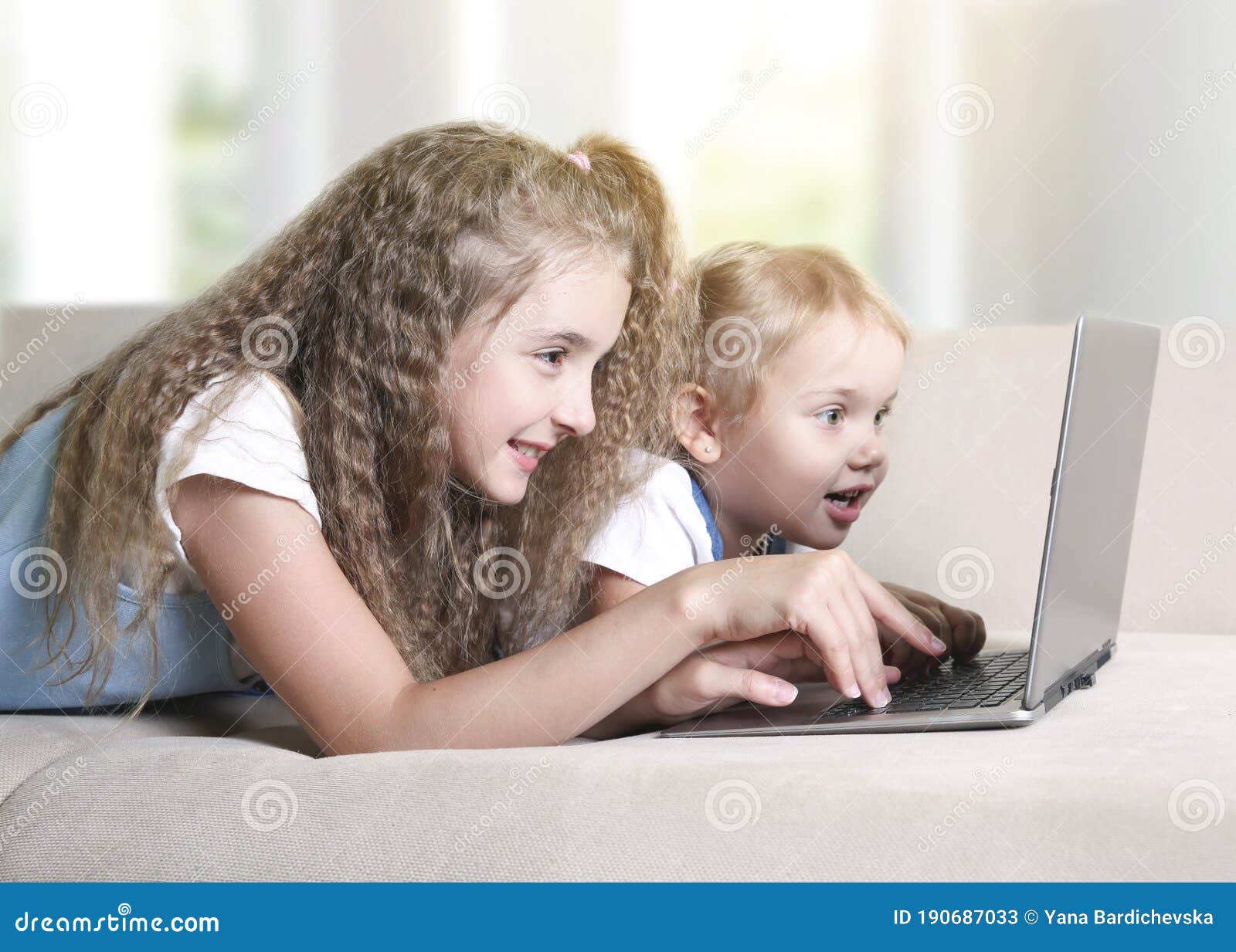Children Lying on Sofa and Watching the Screen of Laptop.Kids Using ...