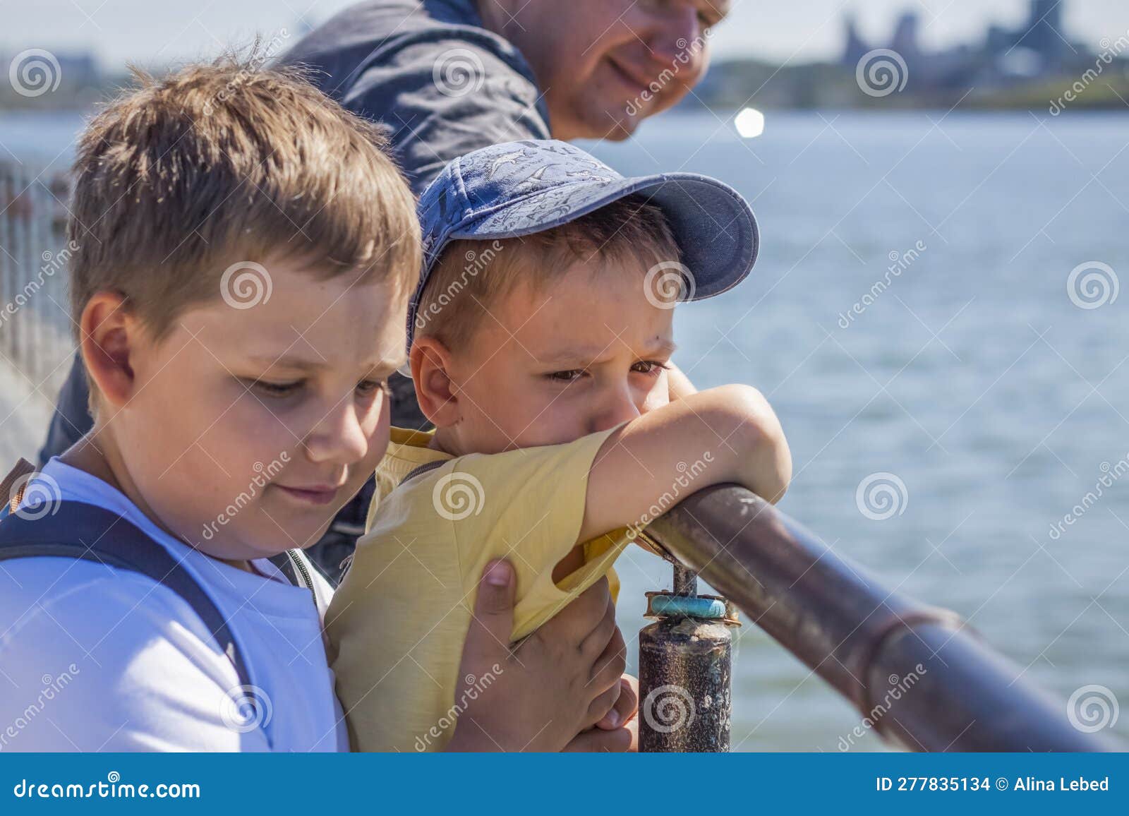 Children and a Man Stand and Look at the River Over the Railing of the ...