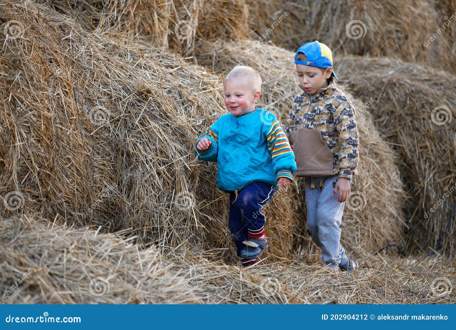 Children Play with a Stack of Straw at Sunset Stock Photo - Image of ...