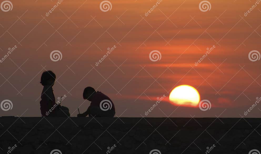 Children Playing at Sunset stock image. Image of dark - 22298291