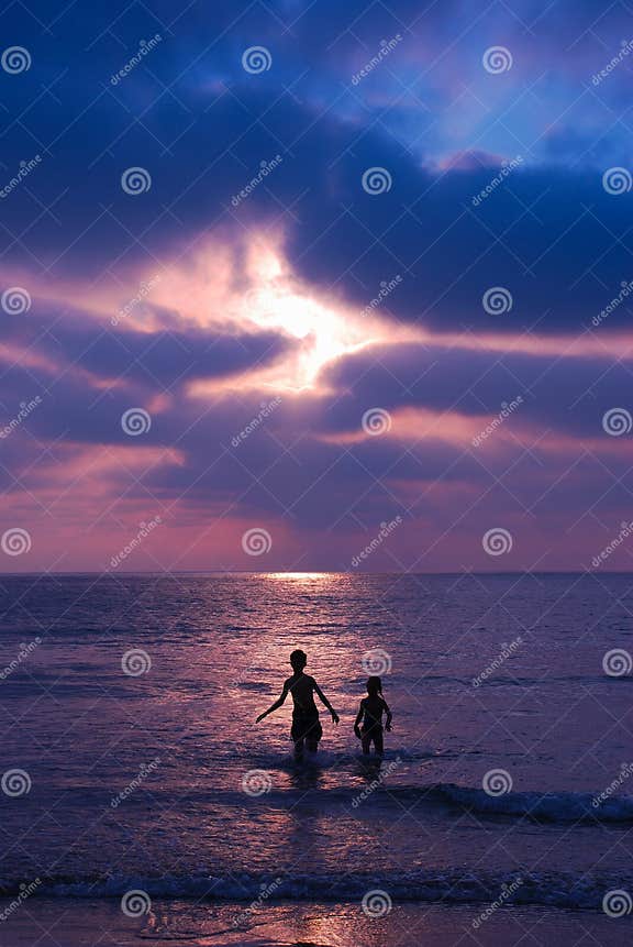 Children Playing at Sunset on the Beach Stock Photo - Image of purple ...
