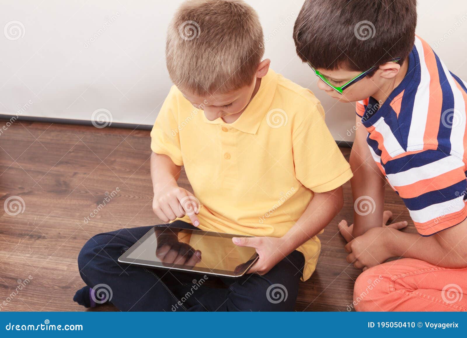 Children playing on tablet stock photo. Image of showing - 195050410
