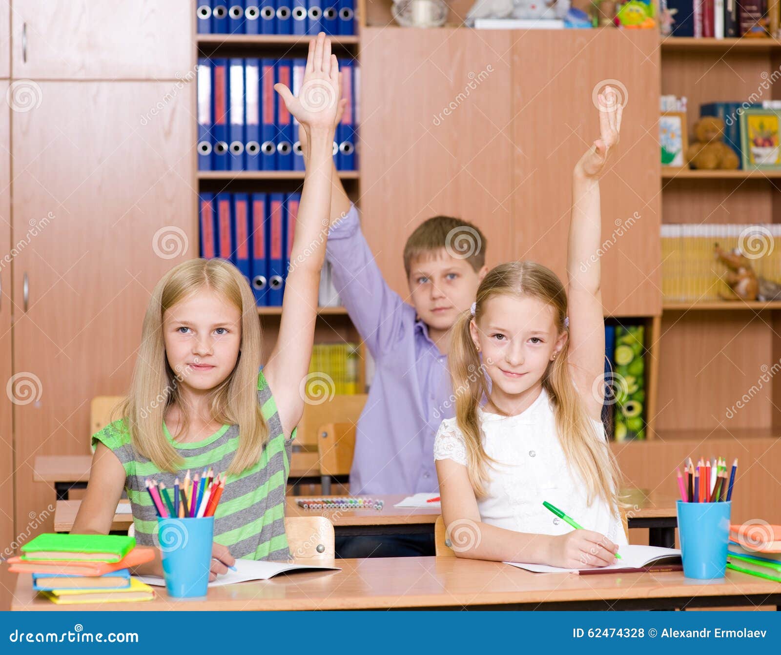Children Raising Hands Knowing the Answer To the Question Stock Photo ...