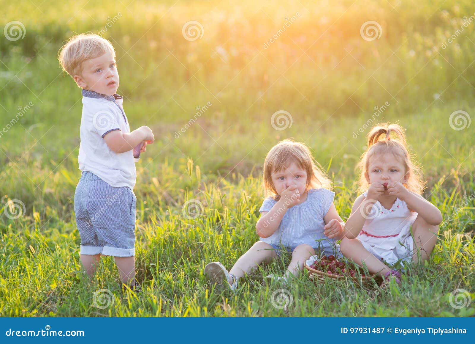 Children sit on the grass stock image. Image of brother - 97931487