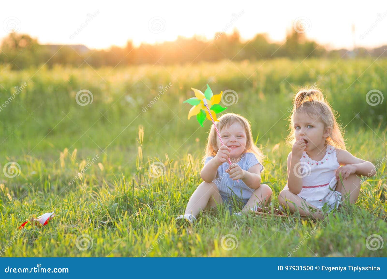 Children sit on the grass stock photo. Image of portrait - 97931500