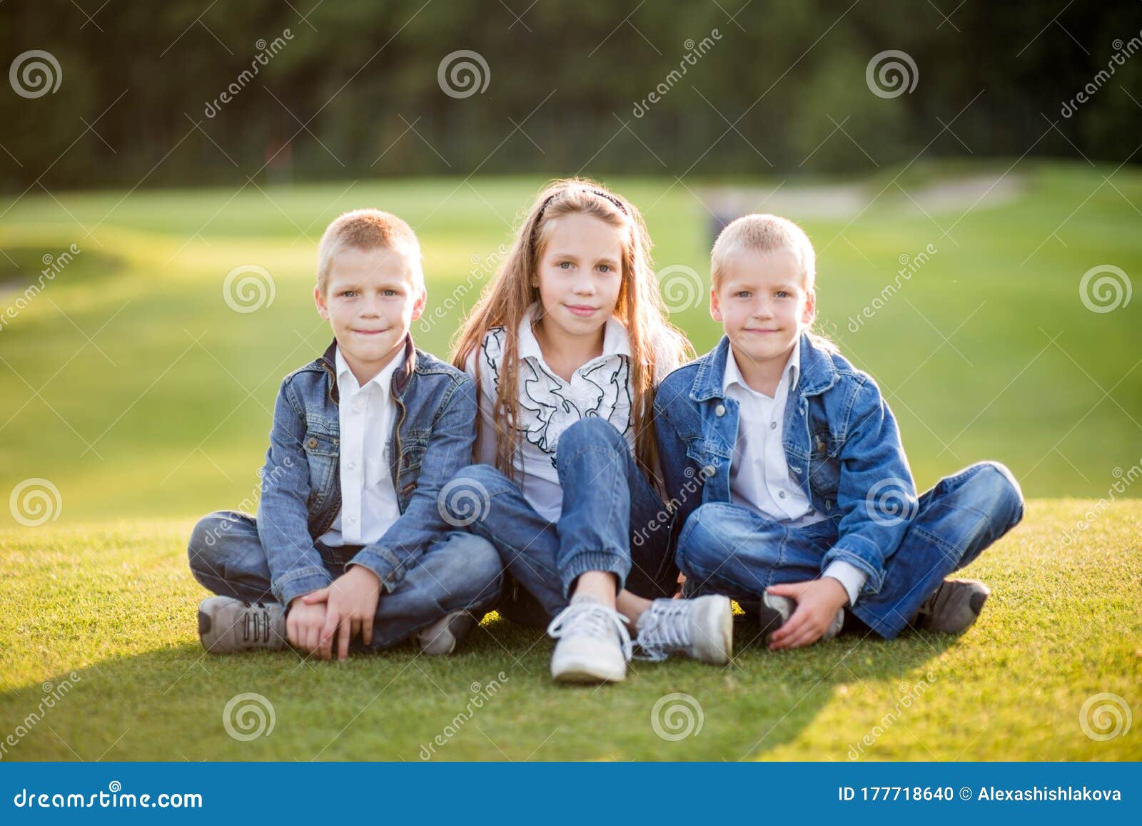 Children sit on the grass stock photo. Image of colorful - 177718640