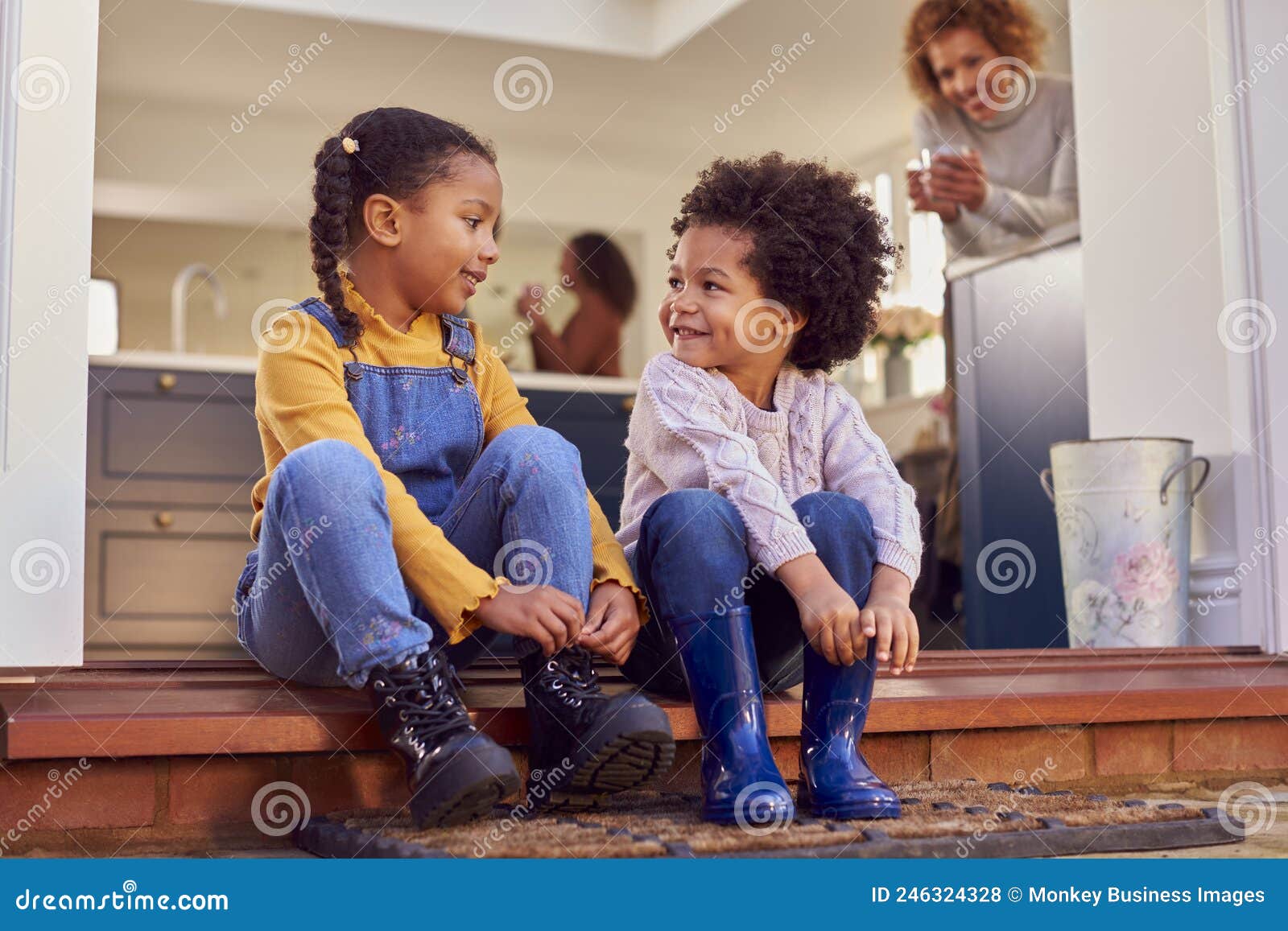 Children Sitting on Step at Home Putting on Boots before Going on ...