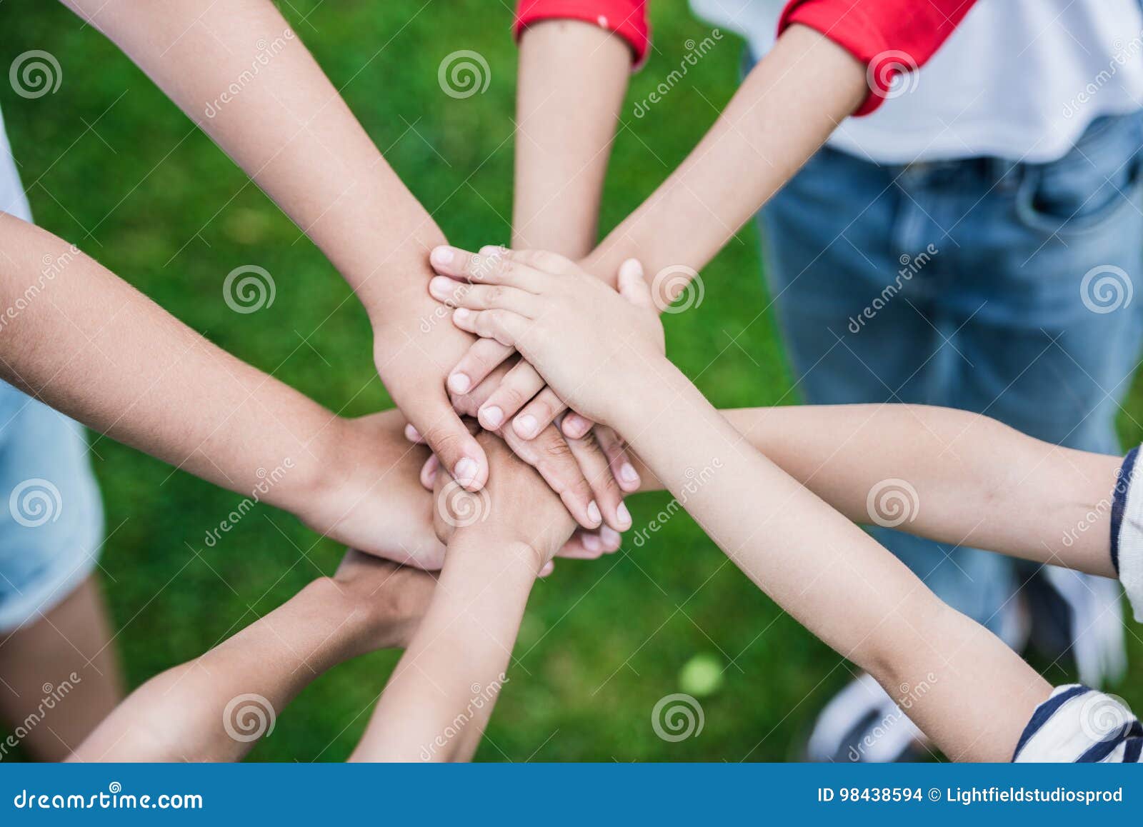 Children Stacking Hands while Standing on Green Grass Stock Photo ...