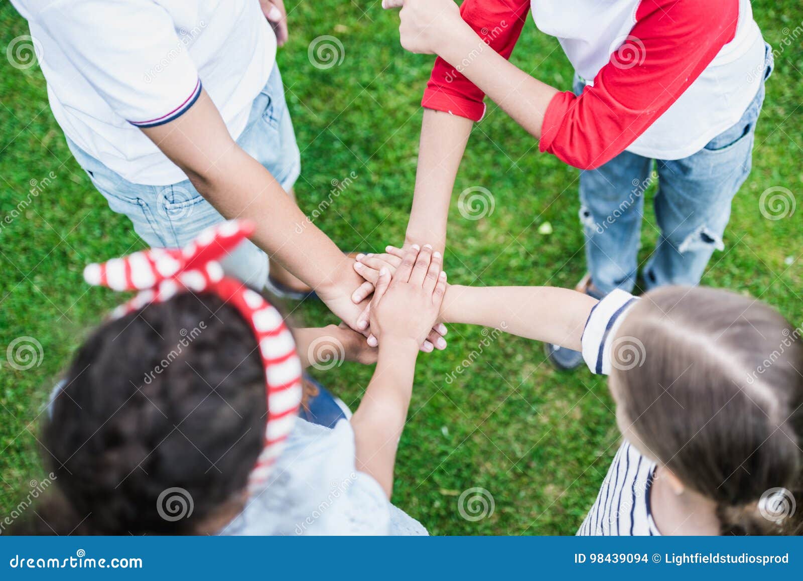 Children Stacking Hands while Standing on Green Grass Stock Photo ...