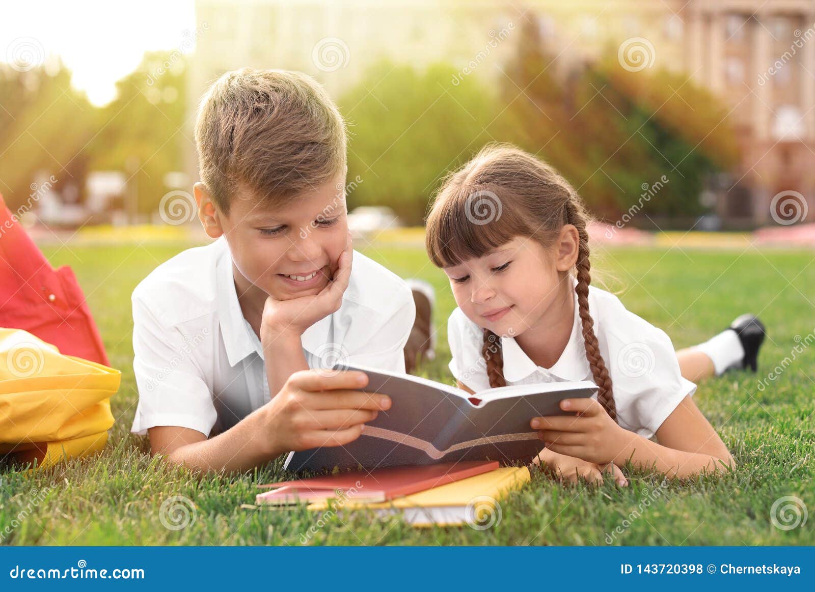 Children with Stationery Doing School Assignment on Grass Stock Photo ...