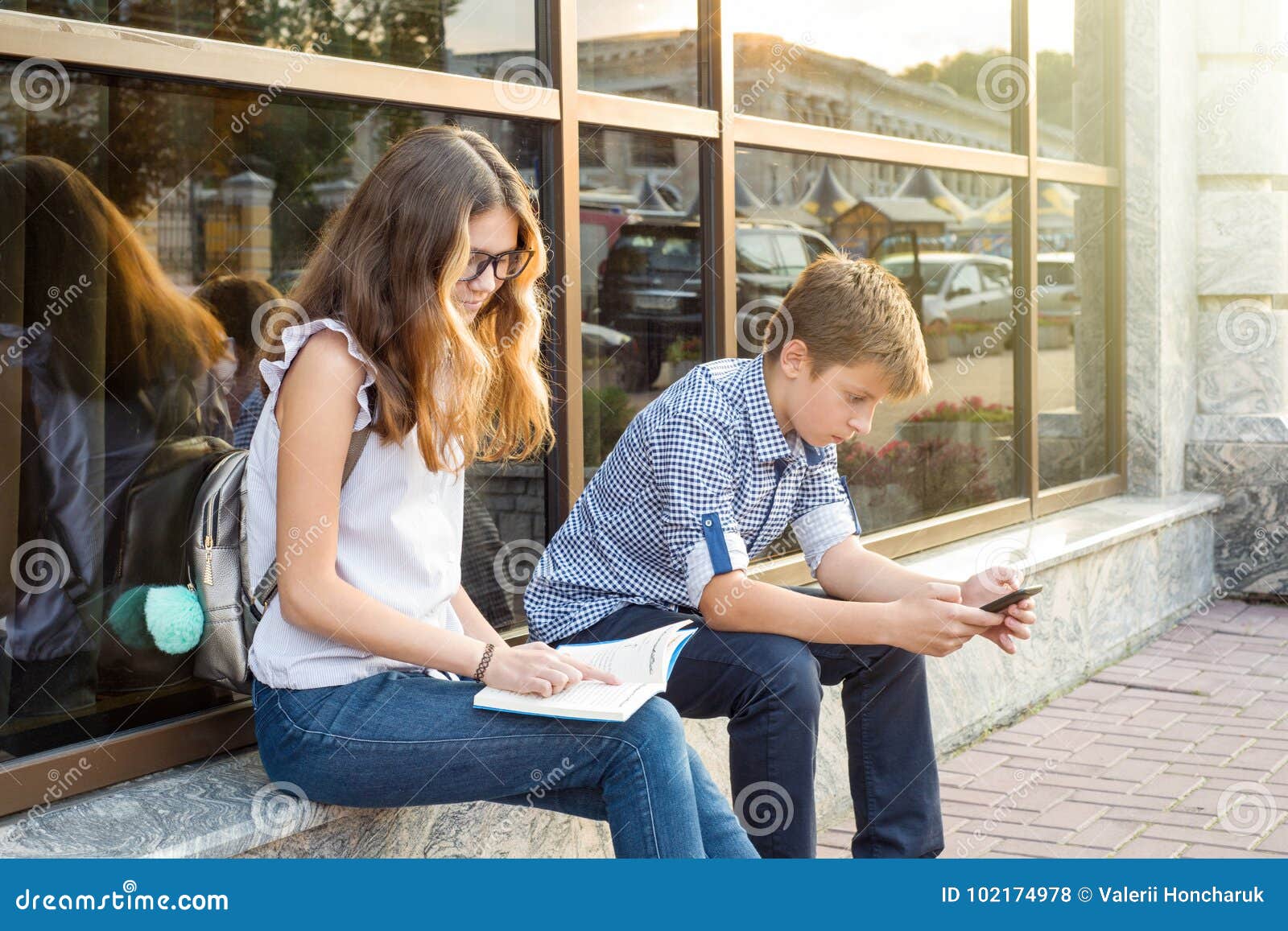 A Children Teenagers, Reading Book and Using Smartphone. Stock Photo ...