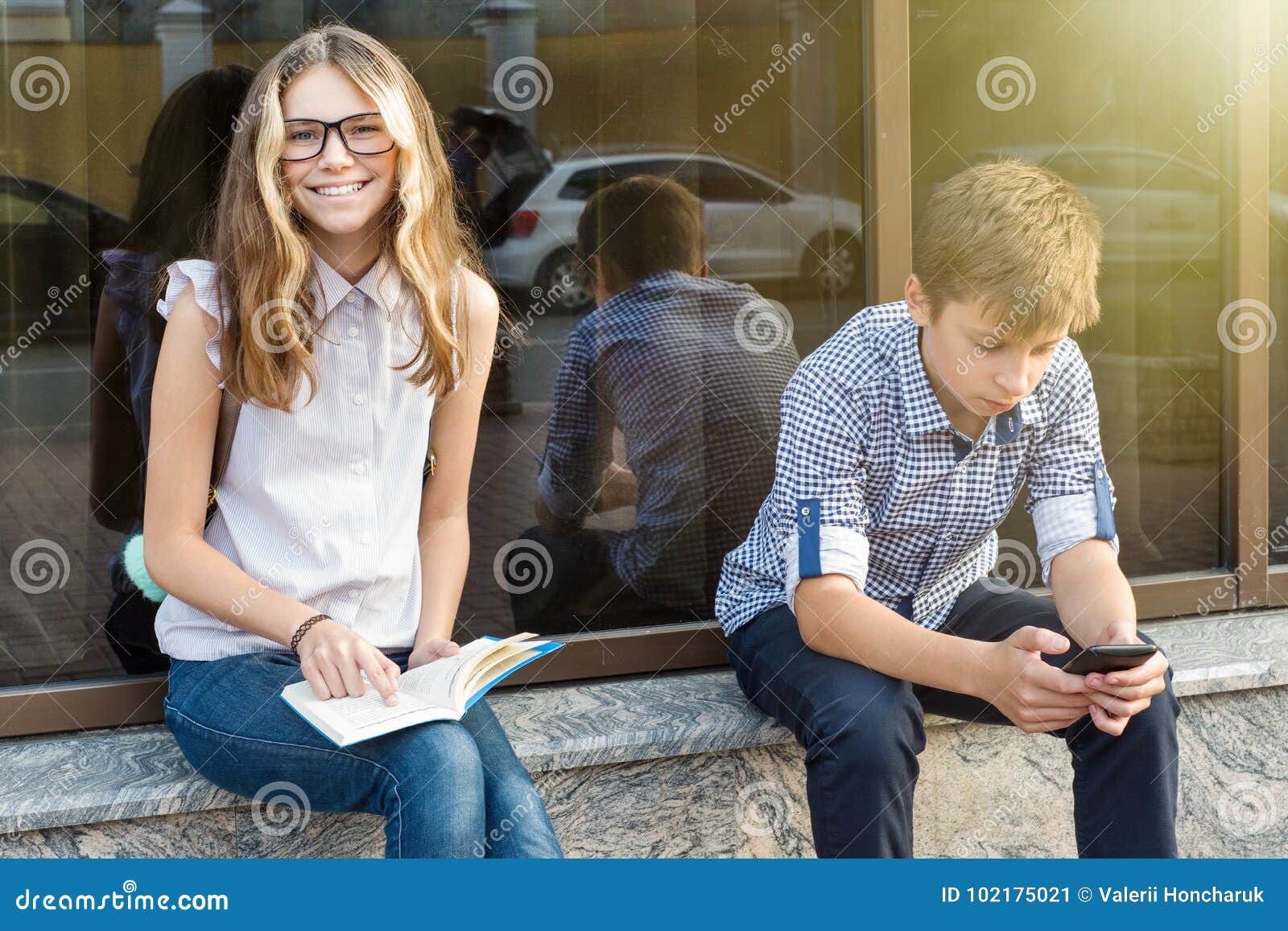 A Children Teenagers, Reading Book and Using Smartphone. Stock Image ...