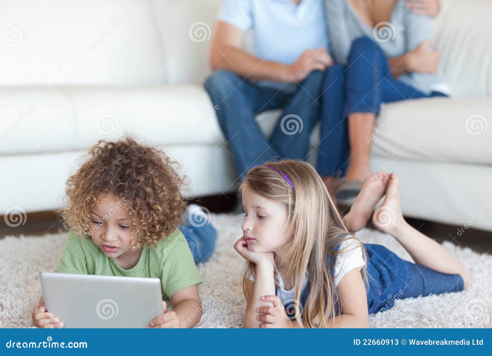 Children Using a Tablet Computer while Their Parents are Watching Stock ...