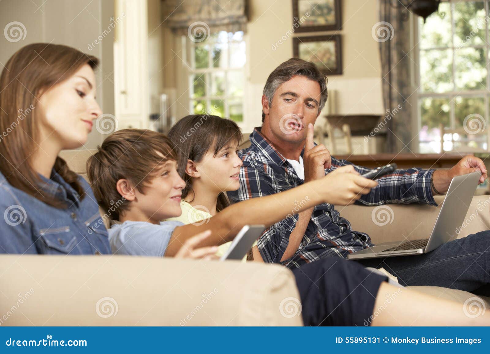 Children Watching TV Whilst Parents Use Laptop and Tablet Computer at ...