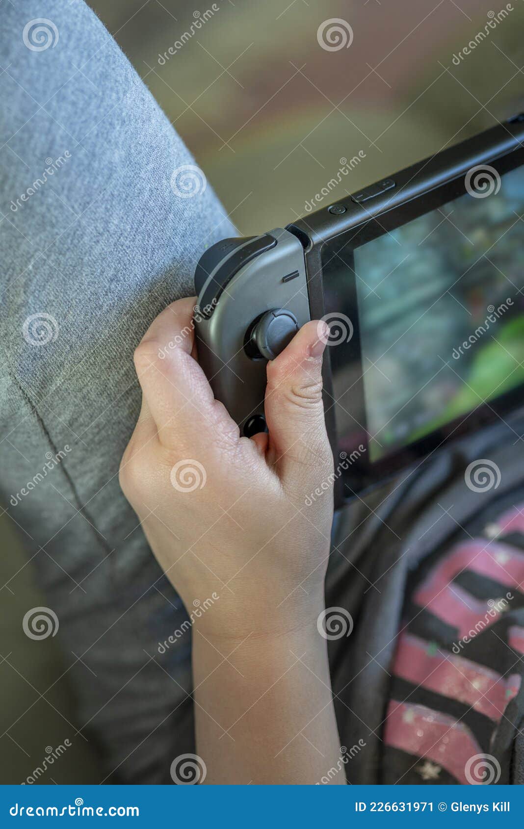 Childs Hand Playing with a Portable Gaming Device. Stock Image - Image ...