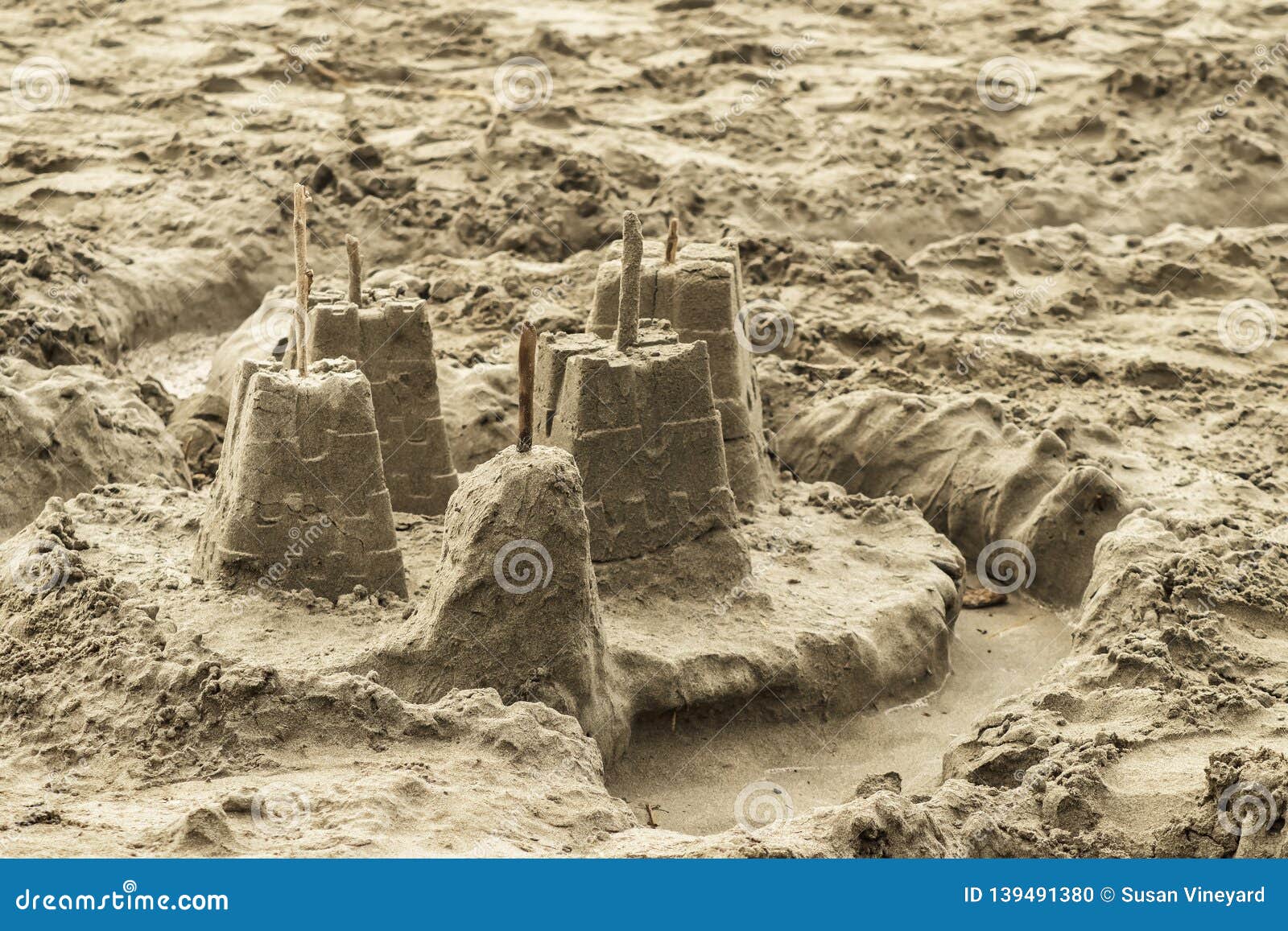 Childs Sand Castle Made from Molds with Sticks for Flags on Top and a ...