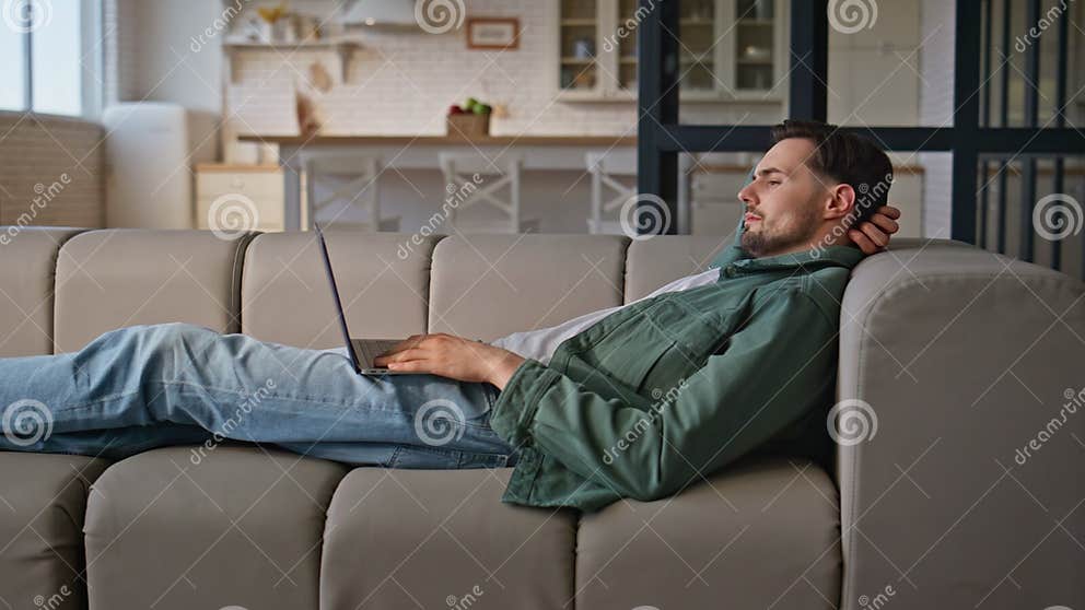 Chilling Freelancer Looking Computer Lying Beige Sofa. Relaxed Man ...