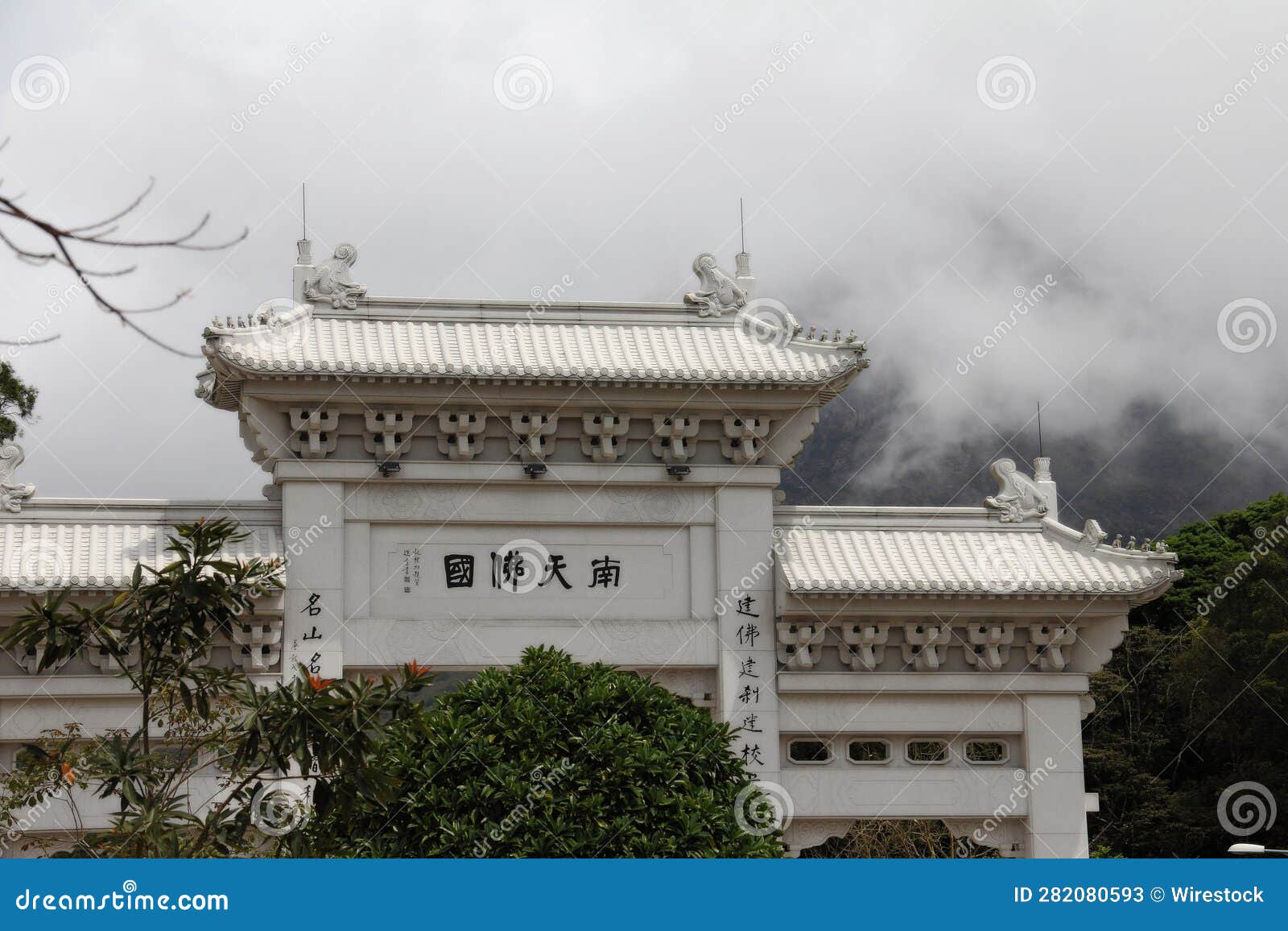 A Chinese Building with Several Buildings on the Side and a Few People ...