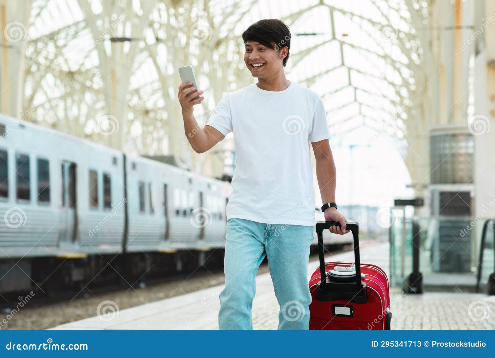 Chinese Guy Tourist Walking by Train Station, Using Smartphone Stock ...