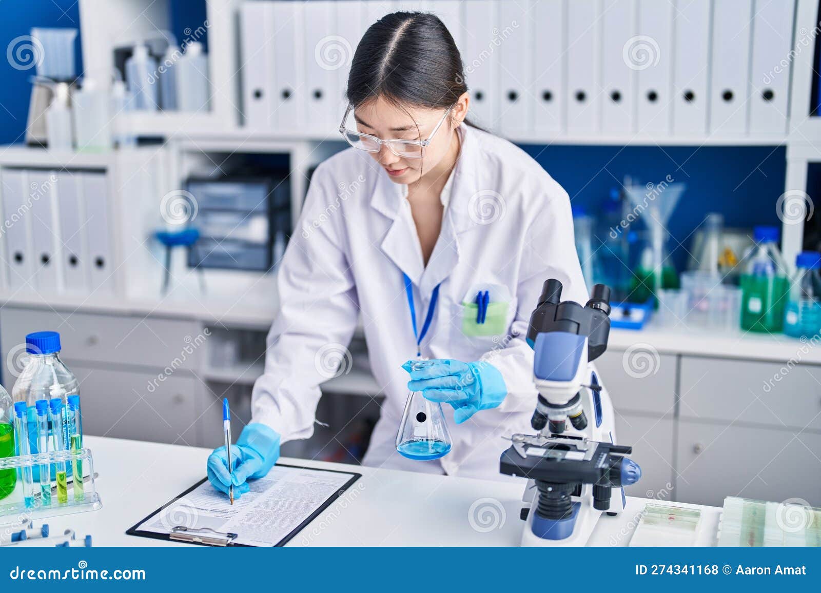Chinese Woman Scientist Measuring Liquid Writing on Document at ...