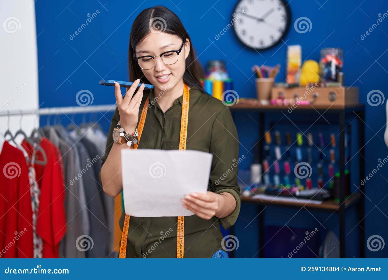 Chinese Woman Tailor Talking on Smartphone Reading Document at Sewing ...