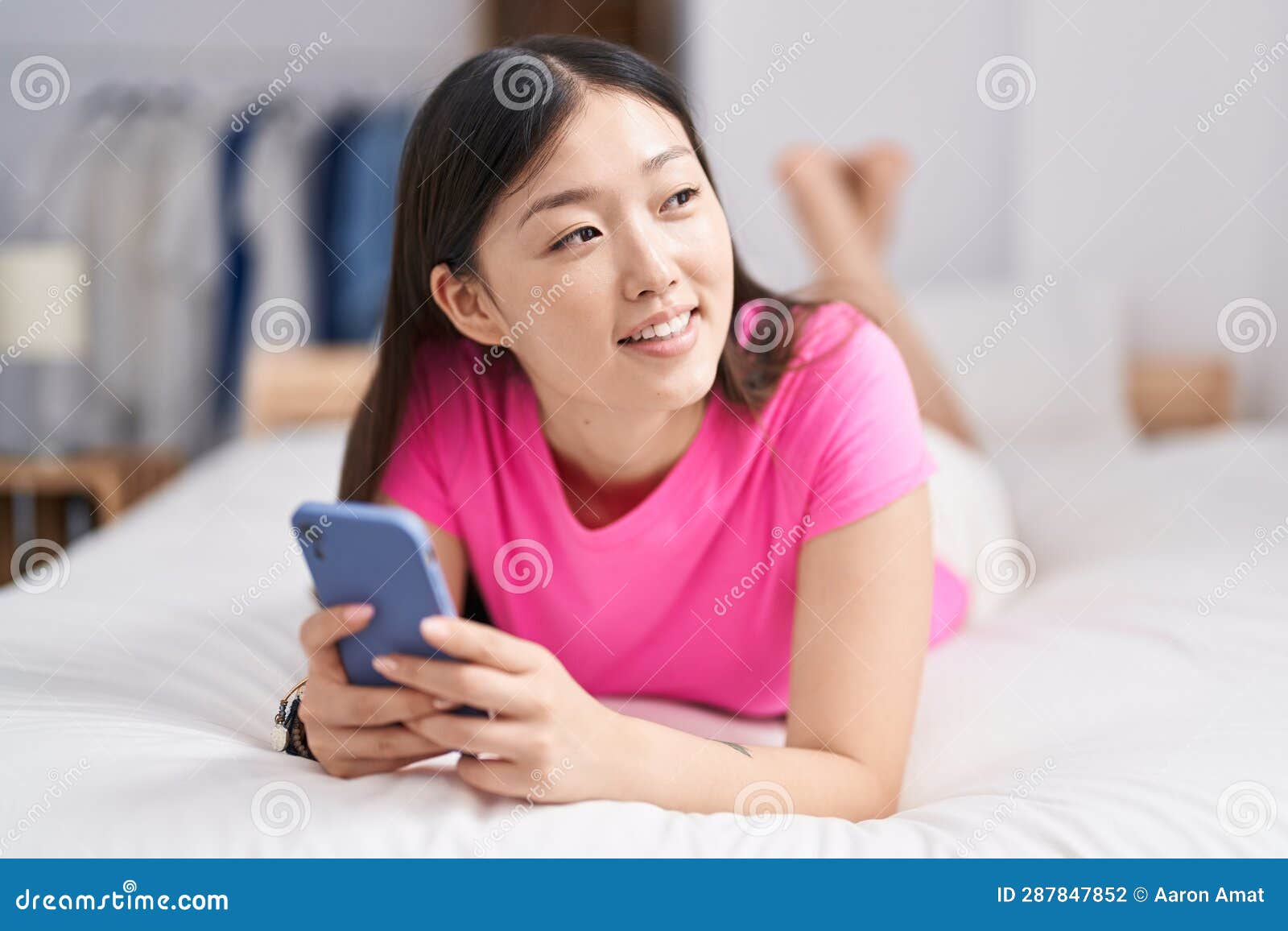 Chinese Woman Using Smartphone Lying on Bed at Bedroom Stock Photo ...
