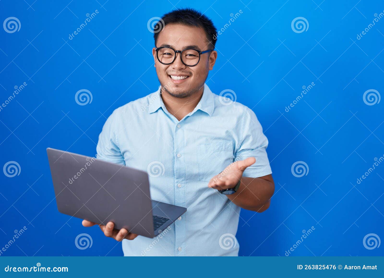 Chinese Young Man Using Computer Laptop Pointing Aside with Hands Open ...