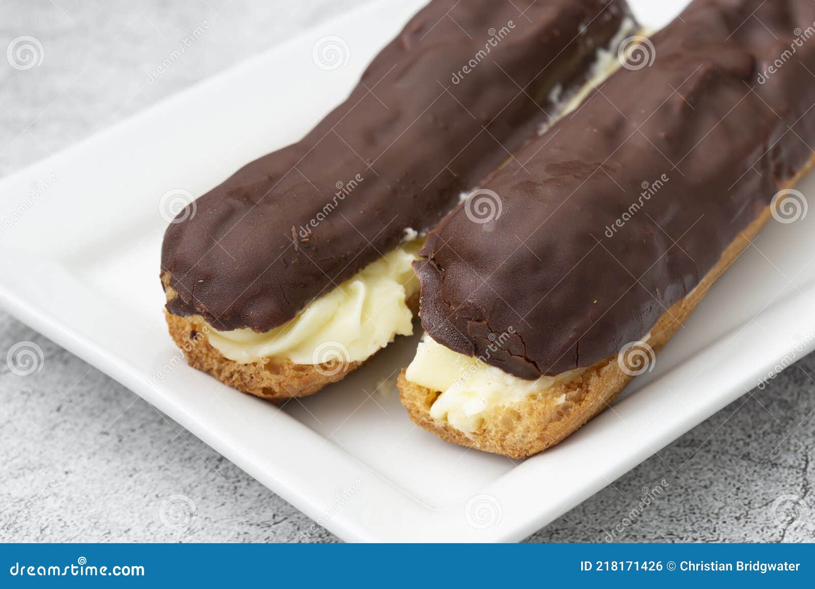 Chocolate Eclair with a Custard Cream Filling on a White Plate. Stock ...