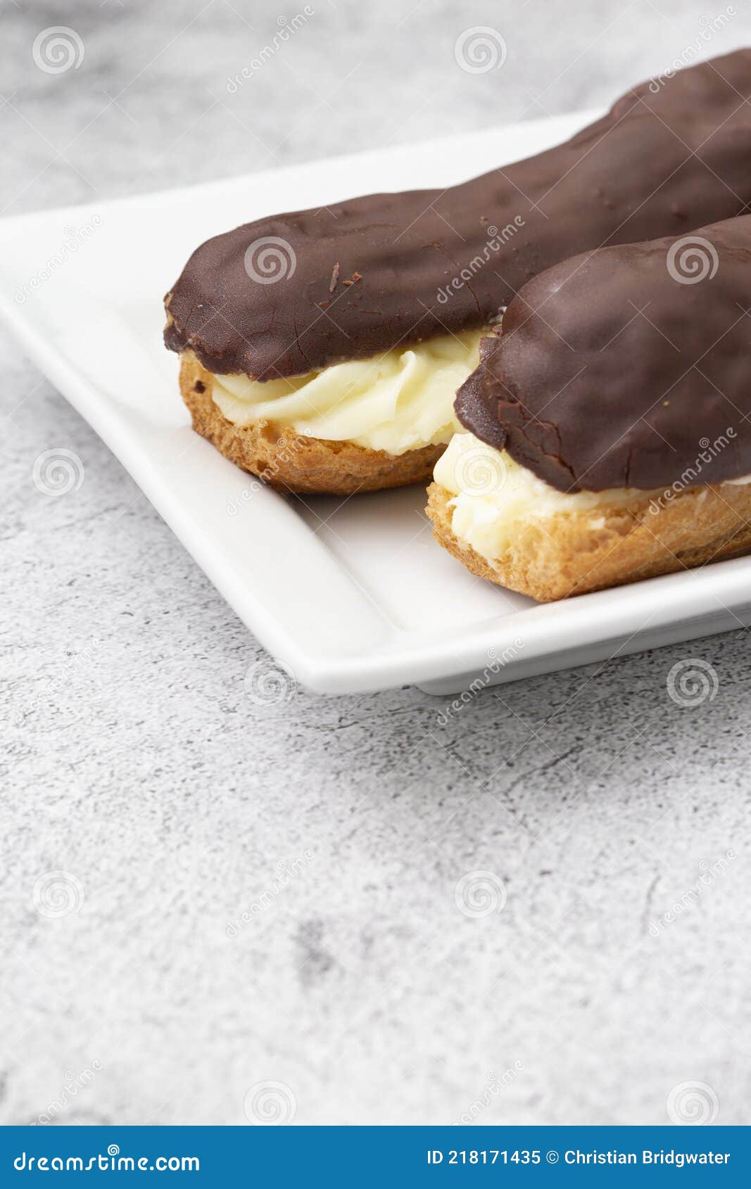Chocolate Eclair with a Custard Cream Filling on a White Plate. Stock ...