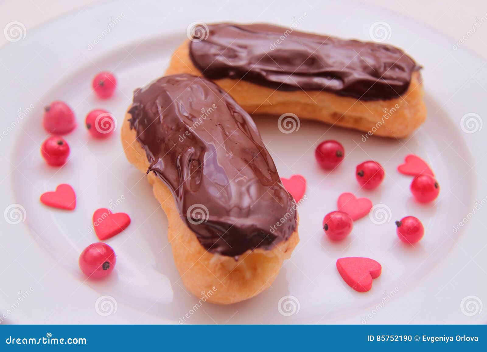 Chocolate Eclairs on Plate on White Background Sprinkled with Red ...