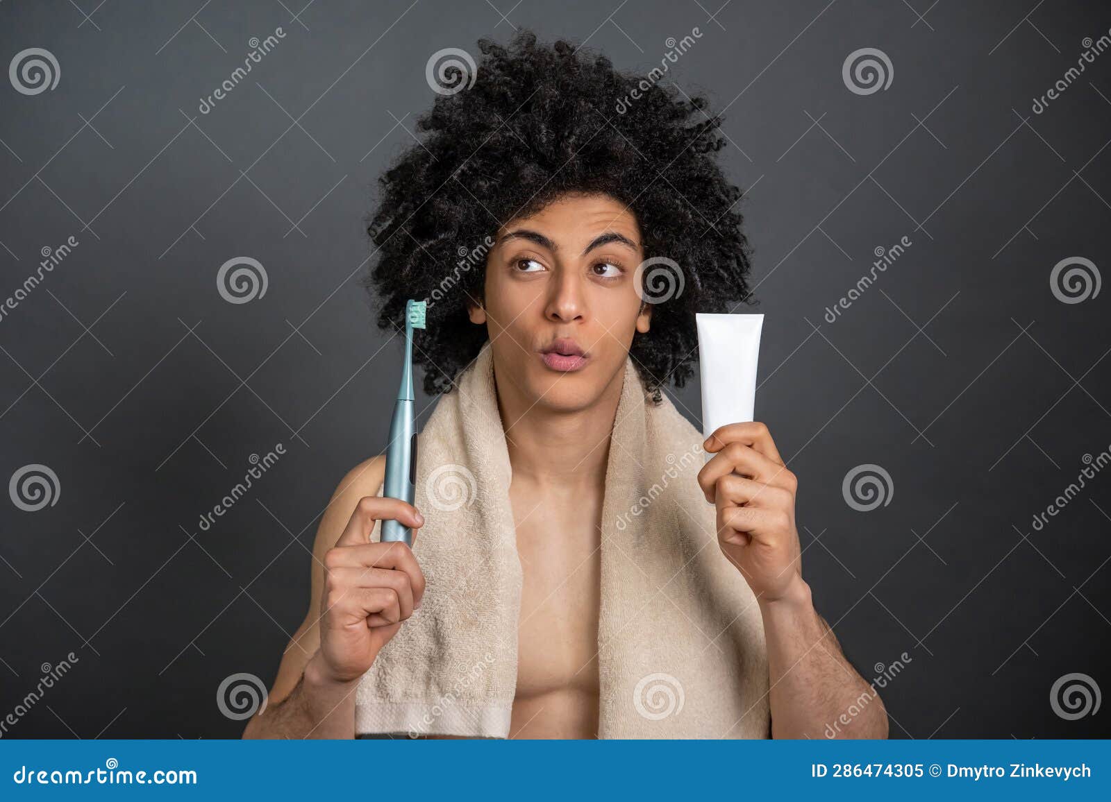 Young Guy Holding Tooth Brush and Toothpaste and Looking Thoughtful ...